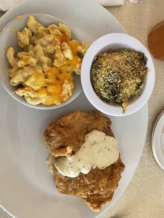 This trinity of comfort&mdash;fried chicken baptized in gravy, cheese-laden mac, and something green to ease your conscience&mdash;is poetry on a plate.
