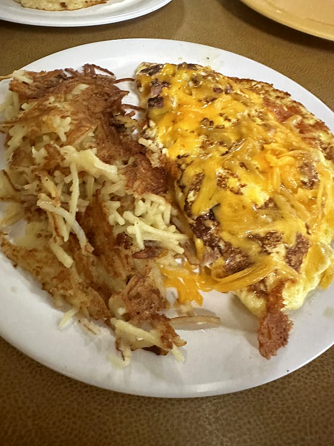 Cheese doesn't just melt here&mdash;it surrenders completely to the omelet. Those hash browns have achieved the perfect crisp-to-tender ratio.
