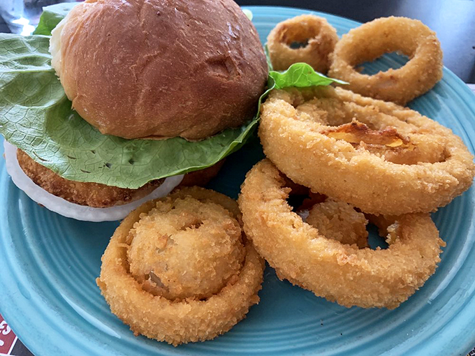 Even with onion rings standing guard, this tenderloin sandwich maintains Indiana's proud tradition of meat-to-bun rebellion.