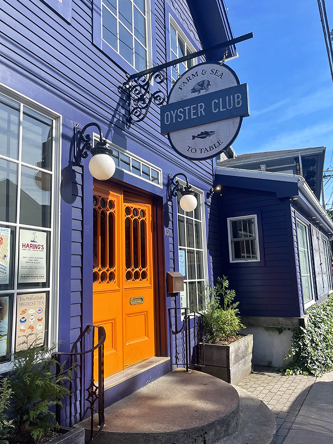 The Oyster Club's striking purple exterior and orange door create the kind of entrance that promises culinary adventure before you've even seen a menu.