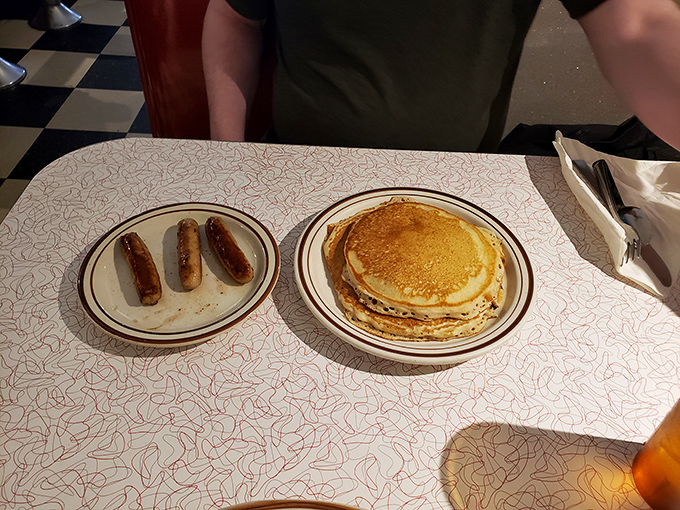 Pancakes stacked like vinyl records from the era the diner celebrates &ndash; golden-brown, perfectly round, and ready for their syrup soundtrack.
