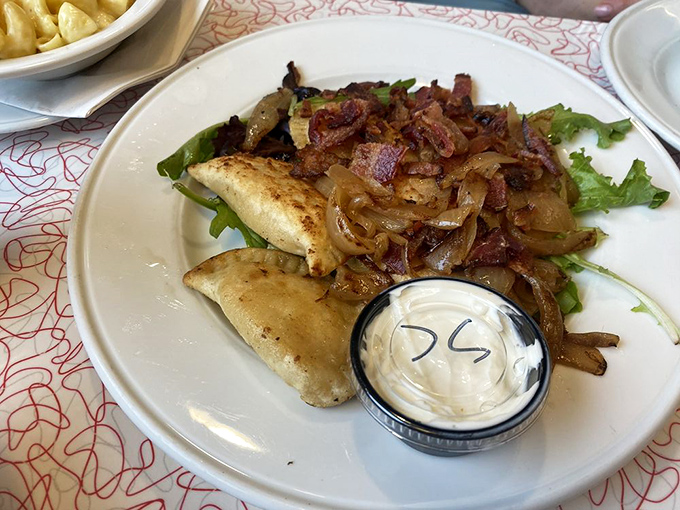 These pierogies aren't just food&mdash;they're little pillows of joy topped with caramelized onions and bacon. The side of sour cream isn't optional, it's essential.