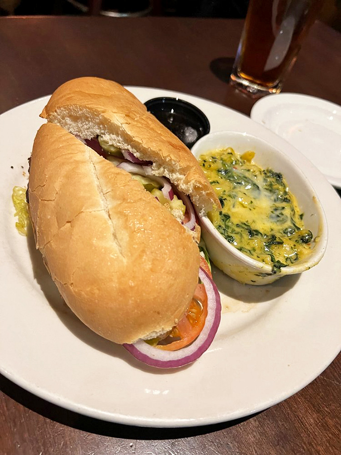 A sandwich that requires both hands and possibly a signed waiver. The Spinach Maria side dish is the unexpected co-star of this plate.