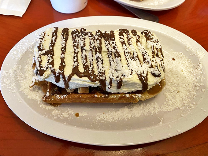 A mountain of whipped cream atop a waffle, drizzled with chocolate&mdash;proof that sometimes the best therapy comes on a plate, not a couch.