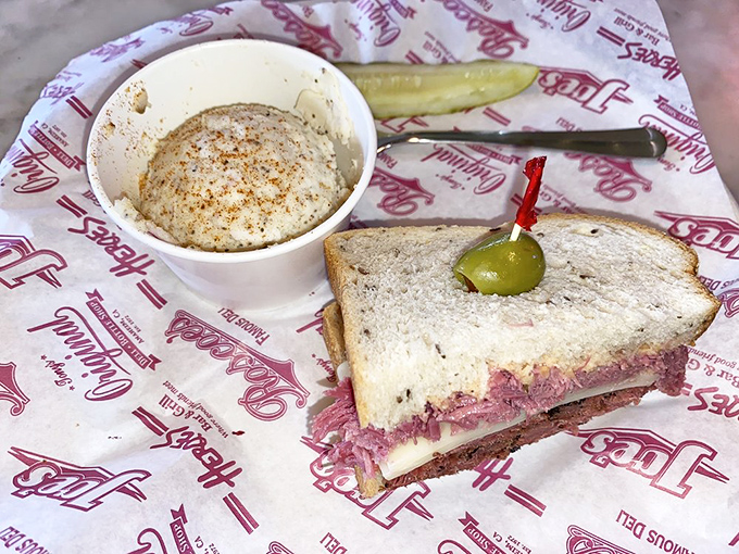 This sandwich isn't just cut in half&mdash;it's presenting itself for your approval. The green olive stands guard like a tiny, briny sentinel protecting flavor territory.