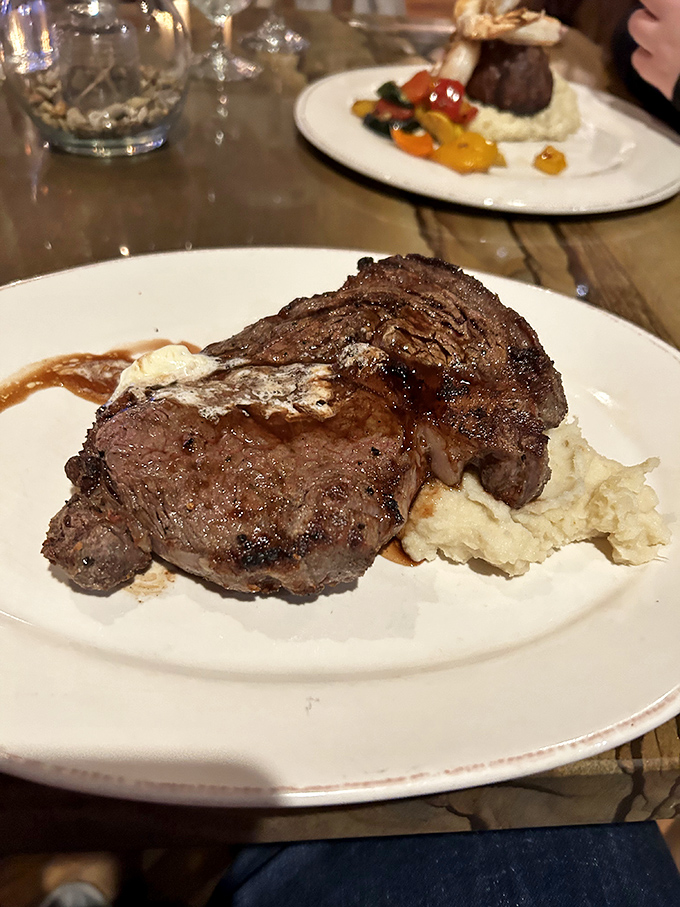 This steak resting on a cloud of mashed potatoes isn't just dinner; it's the comfort food equivalent of a bear hug from your favorite uncle.