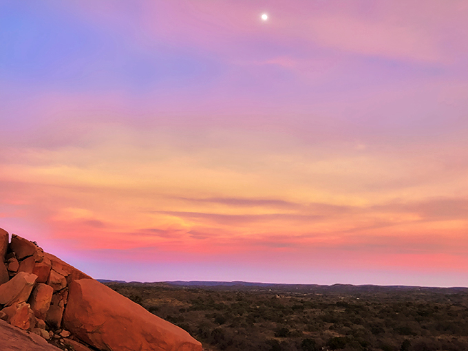 Hill Country sunsets paint the sky in impossible watercolors, turning Enchanted Rock's silhouette into nature's own drama against a cotton candy backdrop.