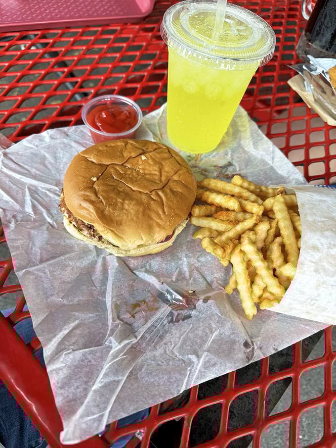 A classic combo that whispers "treat yourself" &ndash; crispy fries, cool lemonade, and a burger awaiting their moment of glory.