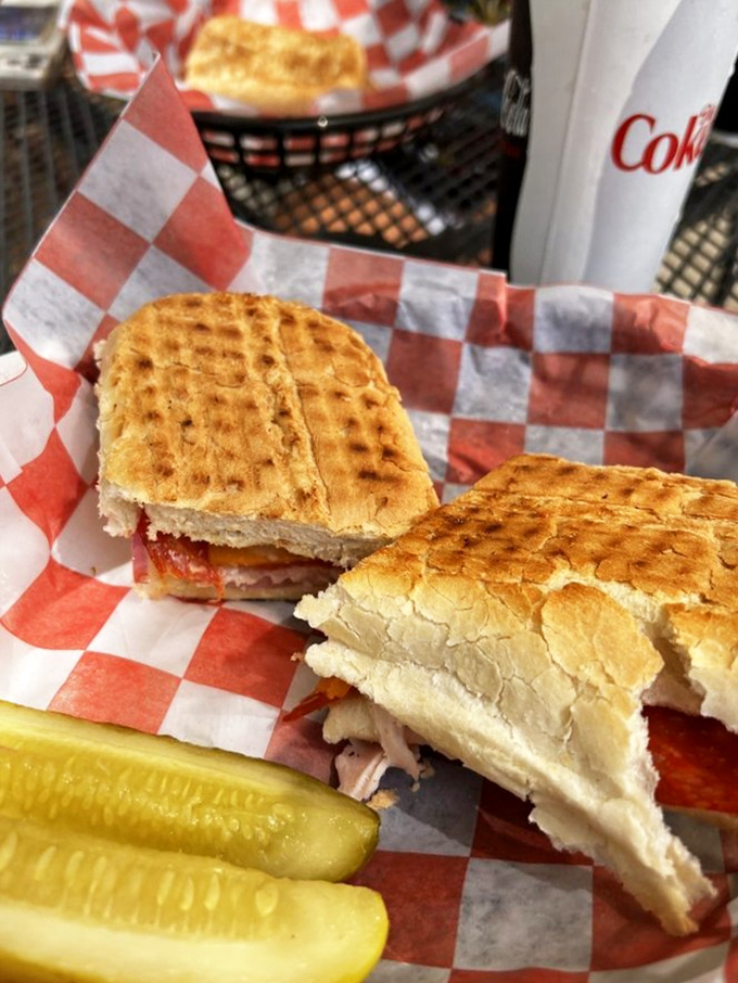Served on classic red and white checkered paper, these sandwiches come with a side of pickle and zero pretension. Pure sandwich satisfaction.