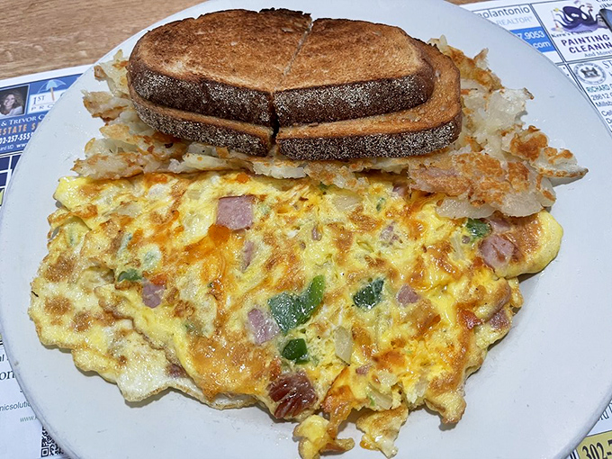 A Western omelet that's seen more ingredients than most people's weekly grocery list, paired with perfectly browned toast for sopping up every last morsel.
