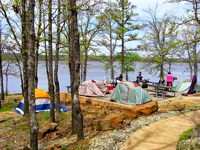 Colorful tents dot the shoreline campground where morning coffee tastes infinitely better with a side of lakefront sunrise.