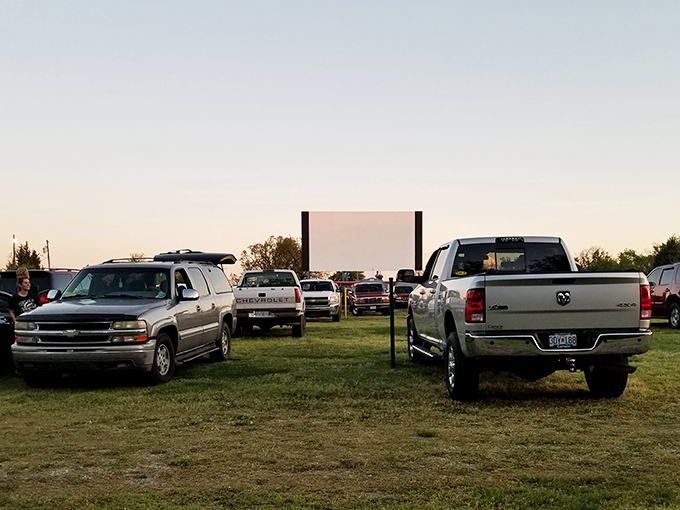 The golden hour at Sunset Drive-In, where pickup trucks and sedans alike transform into personal living rooms under the open sky.