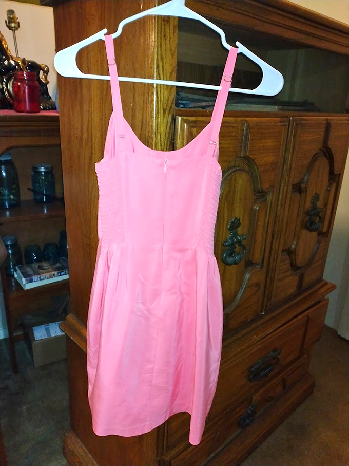 That perfect pink summer dress hanging against vintage cabinetry &ndash; someone's "too small" becomes your "just right" fashion statement.