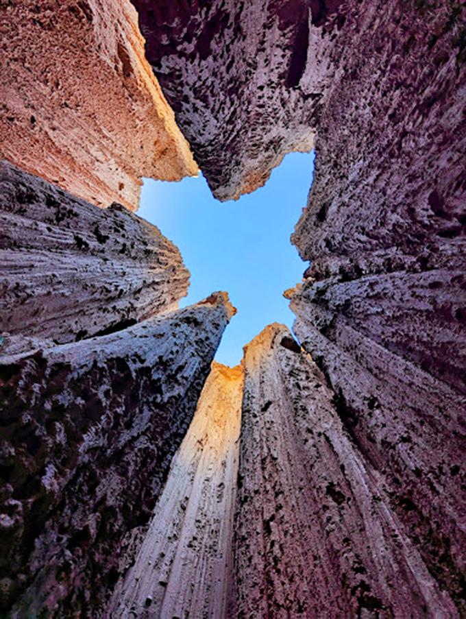 Looking up from inside a slot canyon reveals nature's skylight. This cross-section of eroded bentonite clay tells a 20-million-year story in one glance.