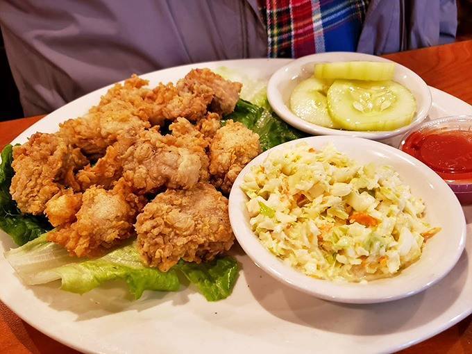Fried chicken nestled beside creamy coleslaw and fresh cucumber slices. A plate that balances indulgence with just enough virtue to ease your conscience.