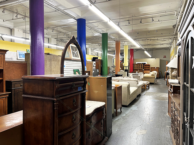 The furniture section resembles a time-travel experiment gone wonderfully right, with mid-century pieces mingling with Victorian-inspired tables under rainbow-painted support columns.