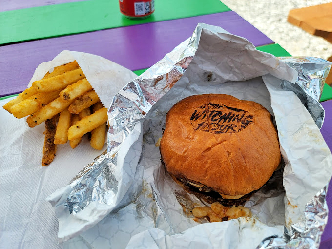 Simple pleasures elevated: A perfectly crafted burger and golden fries, enjoyed al fresco. The logo stamp on the bun is the spooky cherry on top.