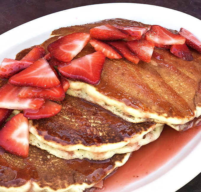 Pancakes topped with fresh strawberries &ndash; because sometimes you need to pretend you're eating something healthy while drowning in maple syrup.