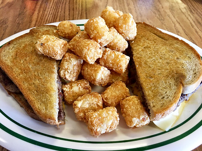 Toast meets meat meets cheese in a sandwich that requires both hands and possibly a nap afterward. Those golden tater tots are no mere sidekicks.