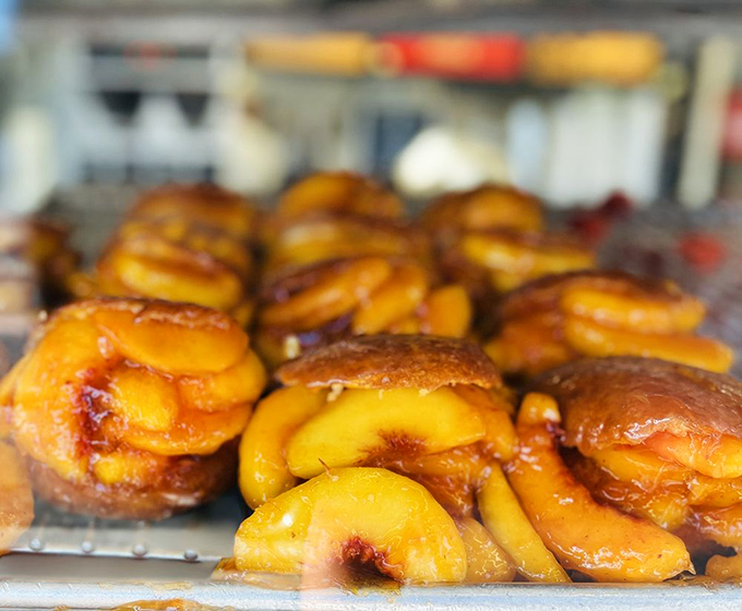 Summer in a donut&mdash;golden peach slices nestled in glazed dough create the kind of seasonal magic that makes waiting in line worthwhile.