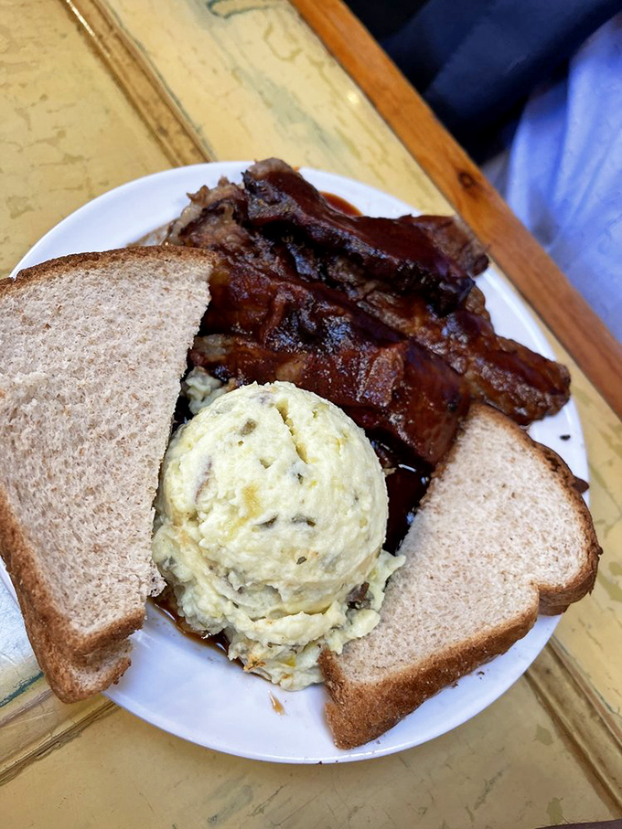 Lunch perfection: ribs with that telltale smoke ring, potato salad that your grandma would approve of, and bread to soak up every last drop.