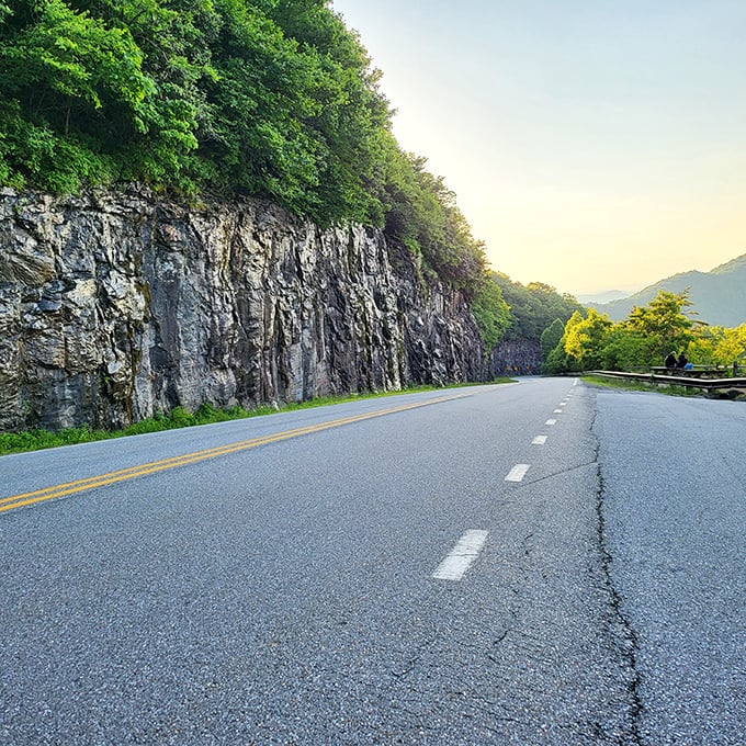 Where mountain meets road in dramatic fashion. These rock faces have witnessed centuries of weather, yet still stand sentinel over travelers.