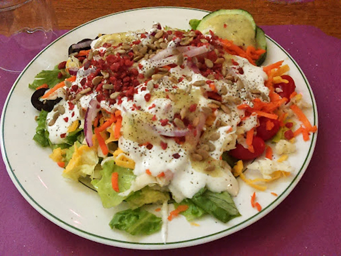 A salad that's trying its best to be healthy while secretly harboring enough ranch dressing and bacon bits to negate any nutritional value. Bless its heart.