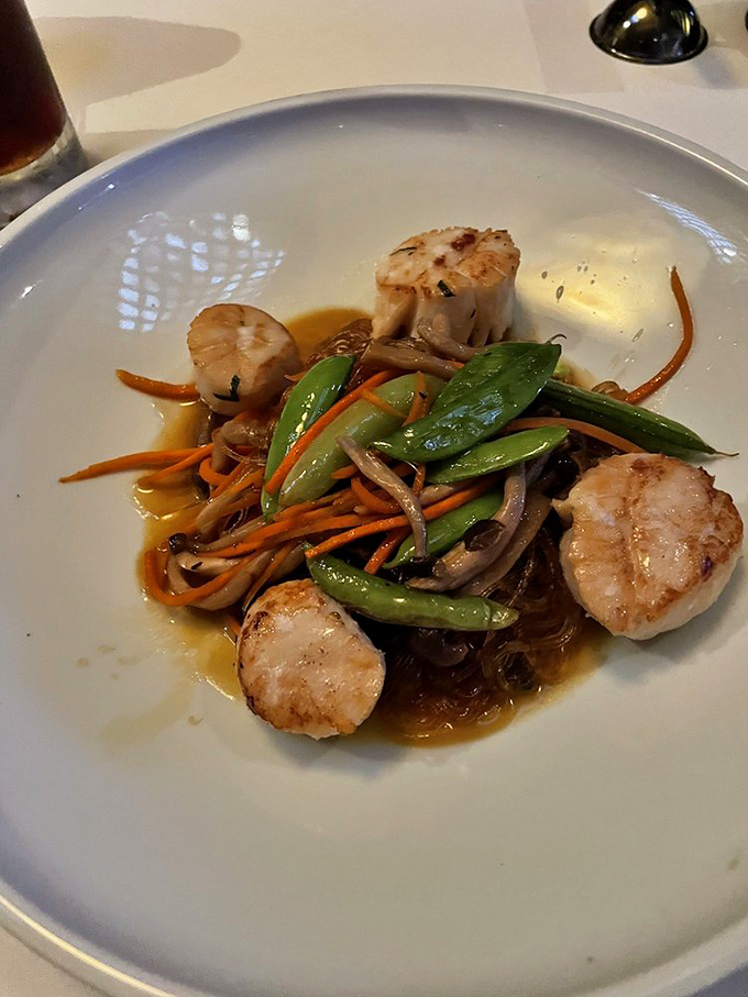 These scallops aren't just seared&mdash;they're transformed into buttery islands in a sea of vibrant vegetables that would make Neptune himself swoon.