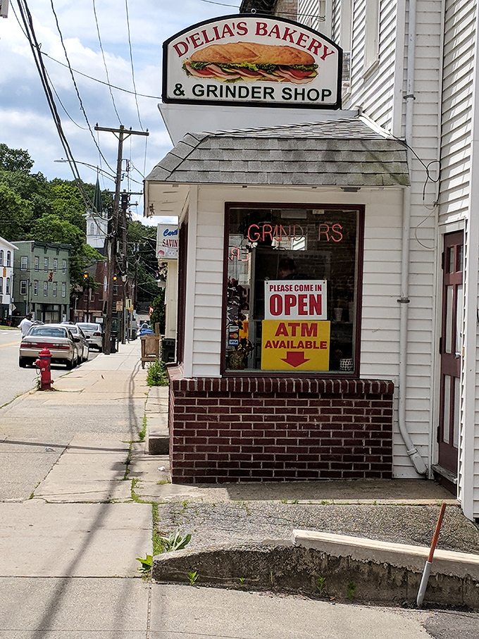 D'Elia's corner entrance says "neighborhood institution" in architectural terms. That neon "OPEN" sign might be Connecticut's most welcome sight.