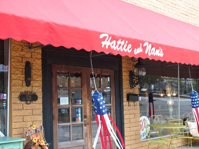 Hattie & Nan's red awning pops against the golden brick like a lipstick kiss on a love letter. Patriotic touches add hometown charm.
