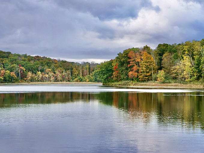 Macedonia Brook's covered bridge welcomes autumn visitors with a carpet of golden leaves&mdash;New England charm in its purest form.