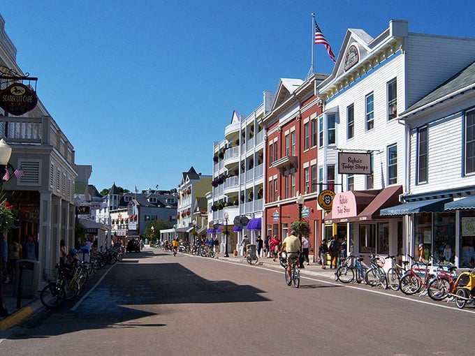 No cars, no problem! Mackinac Island's Main Street bustles with the timeless rhythm of bikes and horse-drawn carriages.
