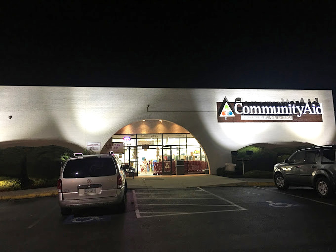 After dark, Community Aid's warm glow beckons night owls to one last bargain before closing time.