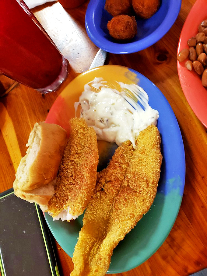 Crispy catfish that would make Mark Twain weep with joy, nestled beside a cloud of mashed potatoes waiting for their gravy waterfall.