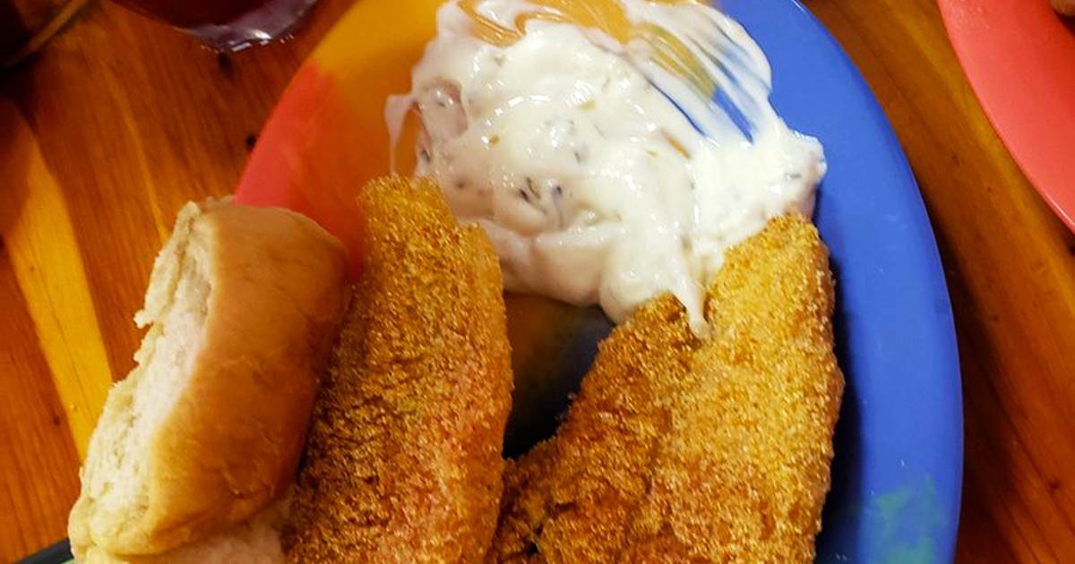 Crispy catfish that would make Mark Twain weep with joy, nestled beside a cloud of mashed potatoes waiting for their gravy waterfall.
