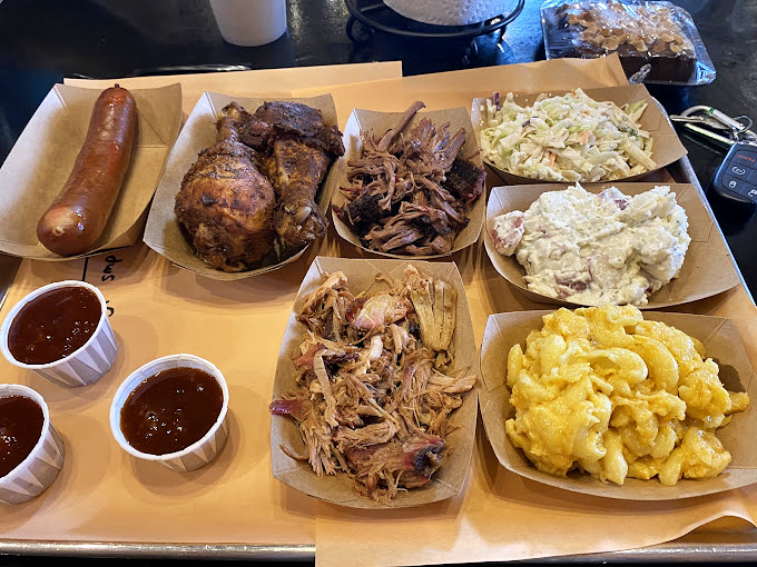 This spread isn't just a meal&mdash;it's a family reunion on a tray. Smoke-kissed meats and homestyle sides create the perfect barbecue symphony.