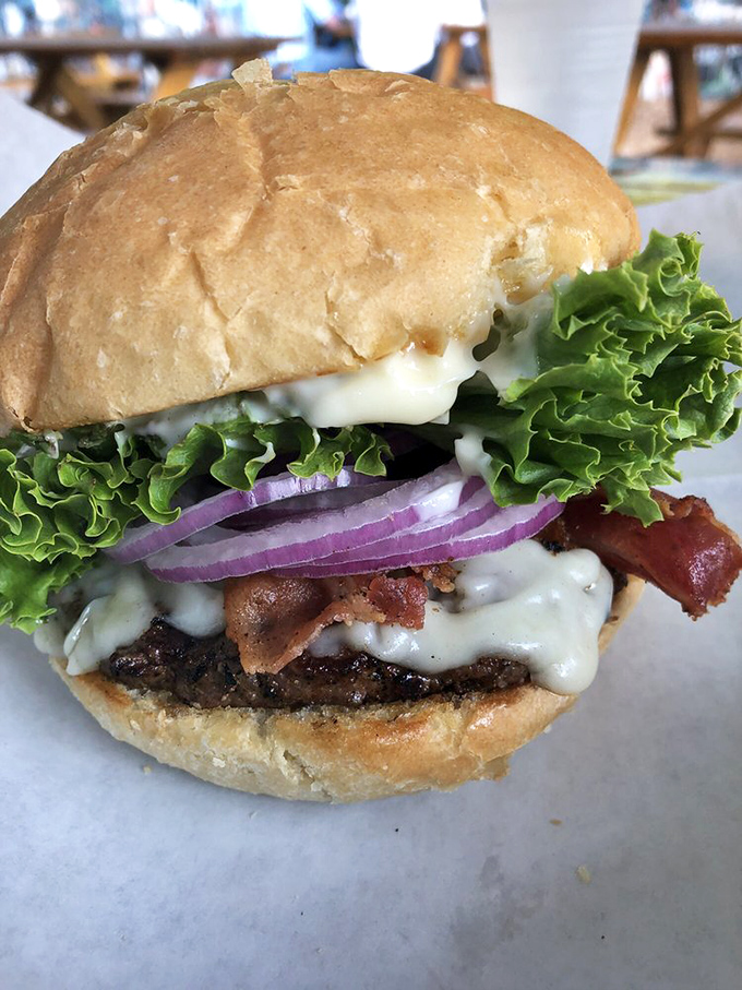 This BYOB (Build Your Own Burger) creation showcases the holy trinity of burger perfection: melty cheese, crisp vegetables, and a patty cooked with respect.