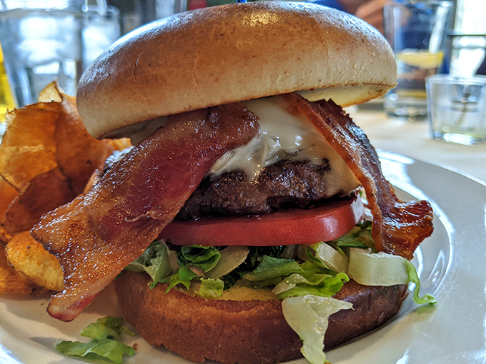 This isn't just a burger&mdash;it's architecture. Layers of bacon, cheese, and fresh vegetables create a towering masterpiece that requires both hands and zero shame.