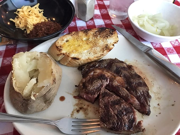 The holy trinity of steak dining: charred ribeye, fluffy baked potato, and golden Texas toast. This is what dreams are made of.
