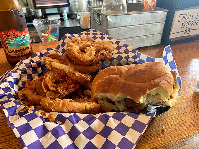 A sandwich and onion rings that would make Neptune himself swim upstream. The blue-checkered paper is just the stage for this seafood performance.
