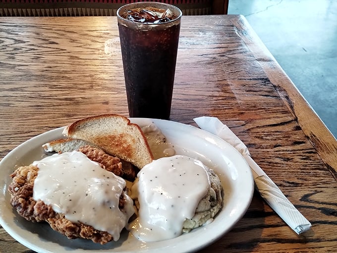 That baked potato isn't just loaded – it's having the time of its life under a blanket of melted butter and pepper gravy that would make a cardiologist wince and a foodie swoon.