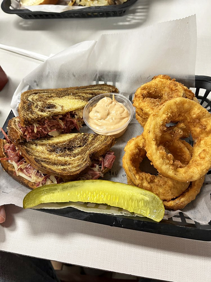 A sandwich so good it gets its own pickle spear bodyguard. The marble rye creates a swirling canvas for the masterpiece within.