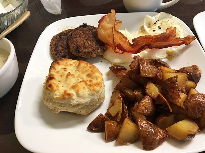 The holy trinity of breakfast: perfectly cooked eggs, a fluffy biscuit, and home fries that remind you why diners are America's true culinary temples.
