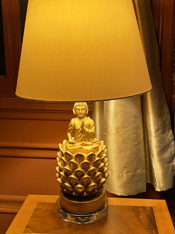 This golden Buddha lamp adds an unexpected touch of zen elegance, proving that historical homes can embrace eclectic design elements too.