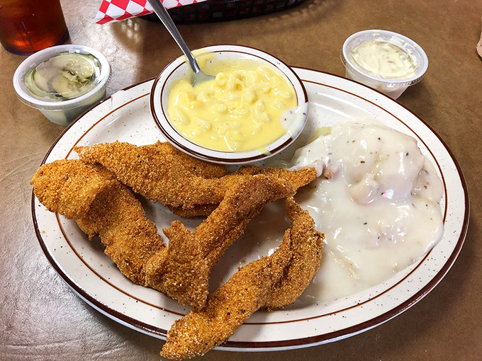 Golden-crusted catfish strips that shatter with each bite, accompanied by creamy mac and cheese and gravy. Southern comfort on a plate, Oklahoma-style.