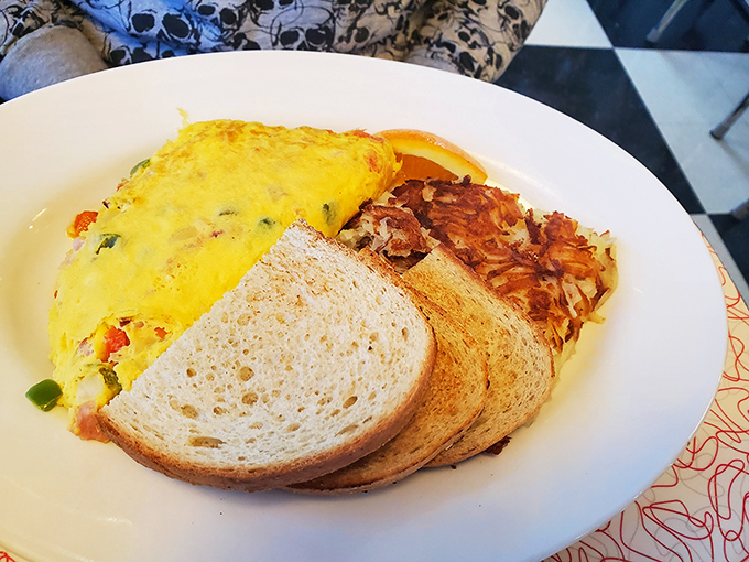 Eggs Benedict with hollandaise that flows like liquid gold, paired with hash browns crisped to mathematical perfection. 