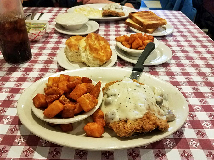Southern comfort on a plate—crispy country fried steak under a blanket of peppery gravy, with those famous sweet potato chunks that could convert a yankee.