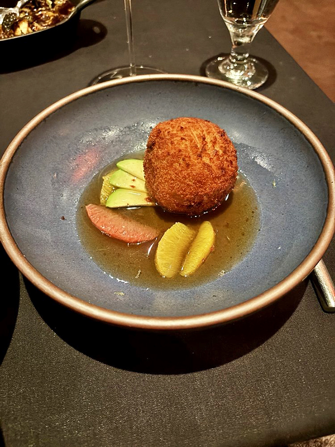 Golden and crisp on the outside, this crab fritter floats in a delicate broth with citrus accents &ndash; a little pond of happiness.