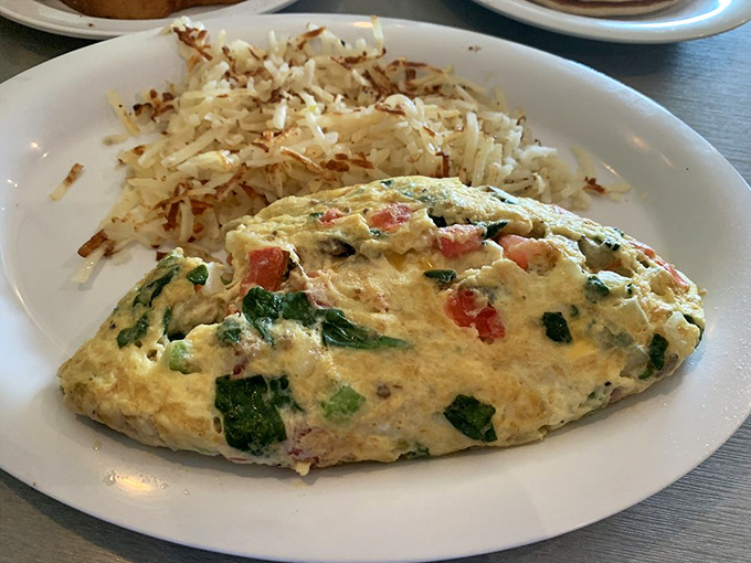 This omelet doesn't just showcase vegetables; it celebrates them. Paired with those hash browns that somehow strike the perfect crispy-to-tender ratio.