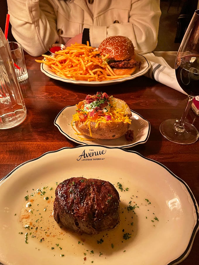 The ultimate dinner table dilemma: a glorious filet mignon competing with a loaded potato and what appears to be a burger worthy of its own zip code.